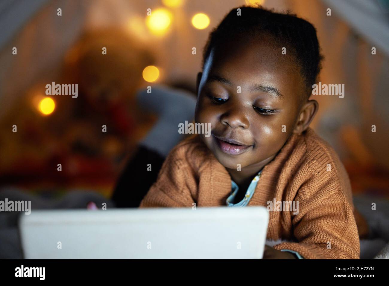 Fun stories make bedtime even better. an adorable little girl using a ...