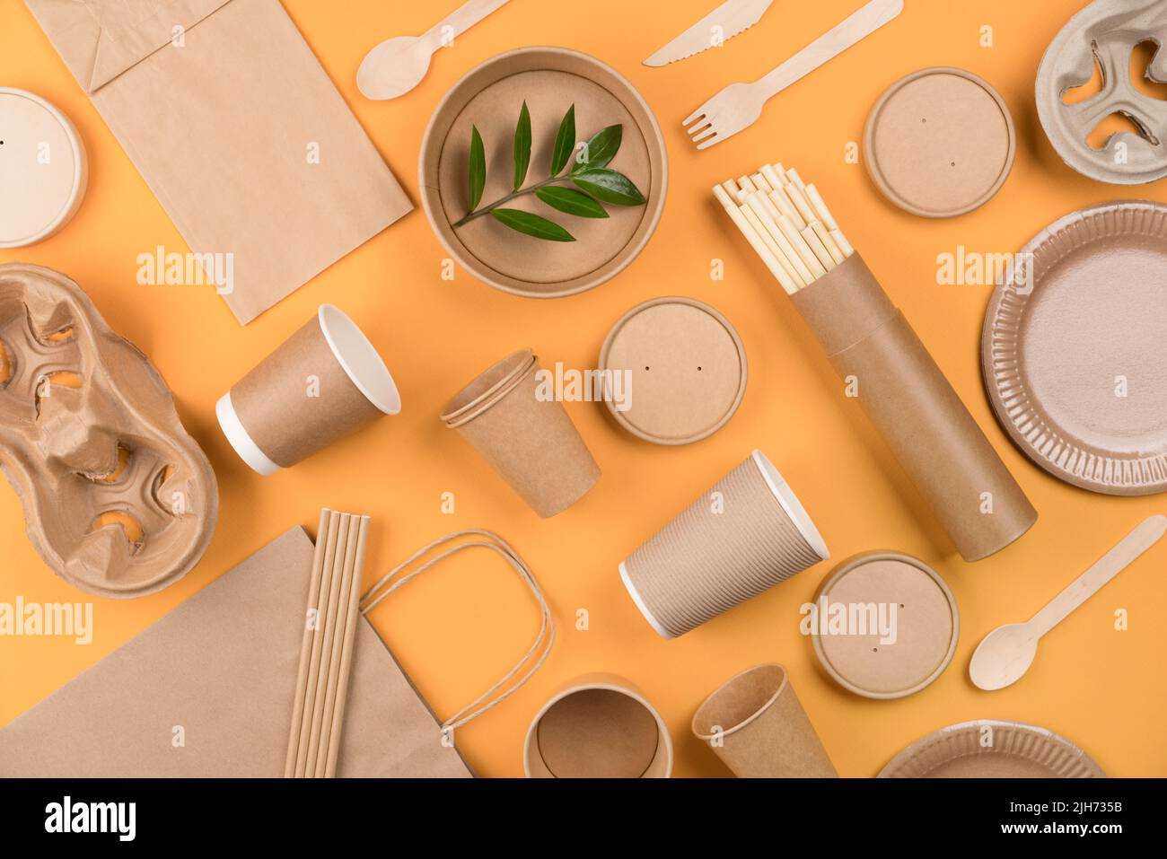 Eco-friendly tableware - kraft paper food packaging over orange ...