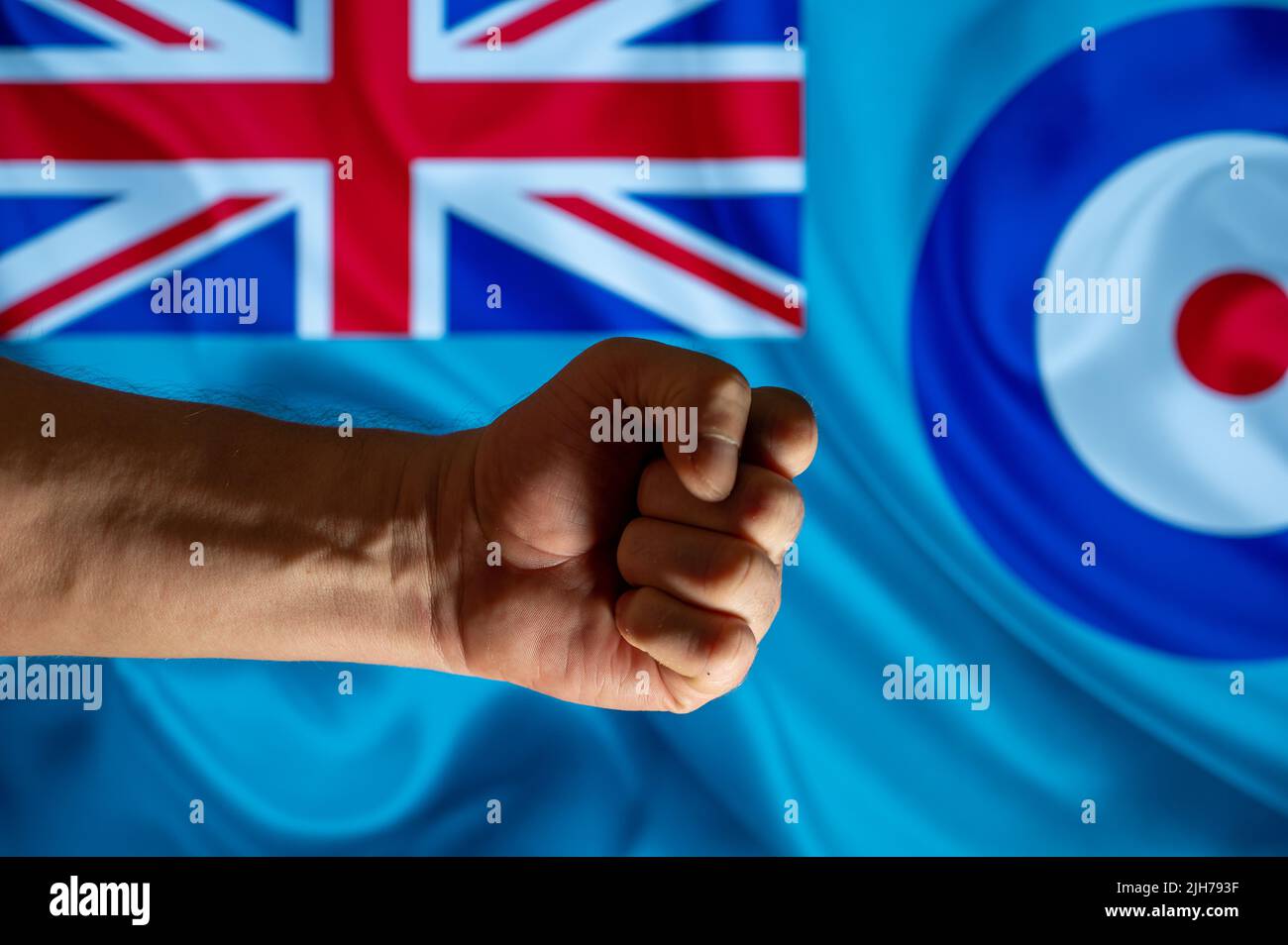 Male hand clenched into fist against blue flag background. Royal Air ...