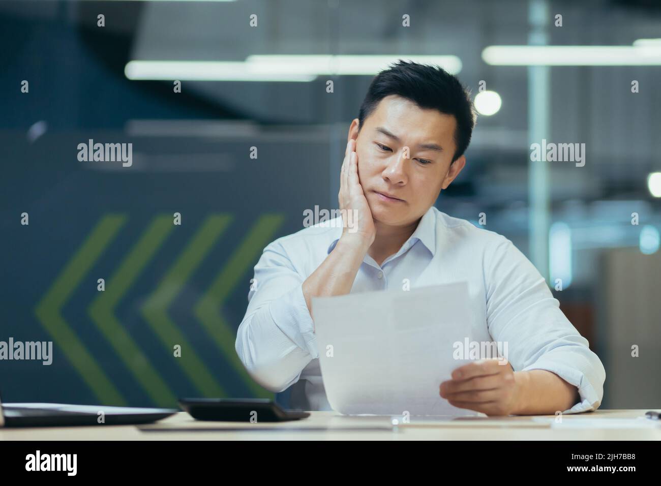 Portrait of a worried young businessman, accountant, financier. He sits ...