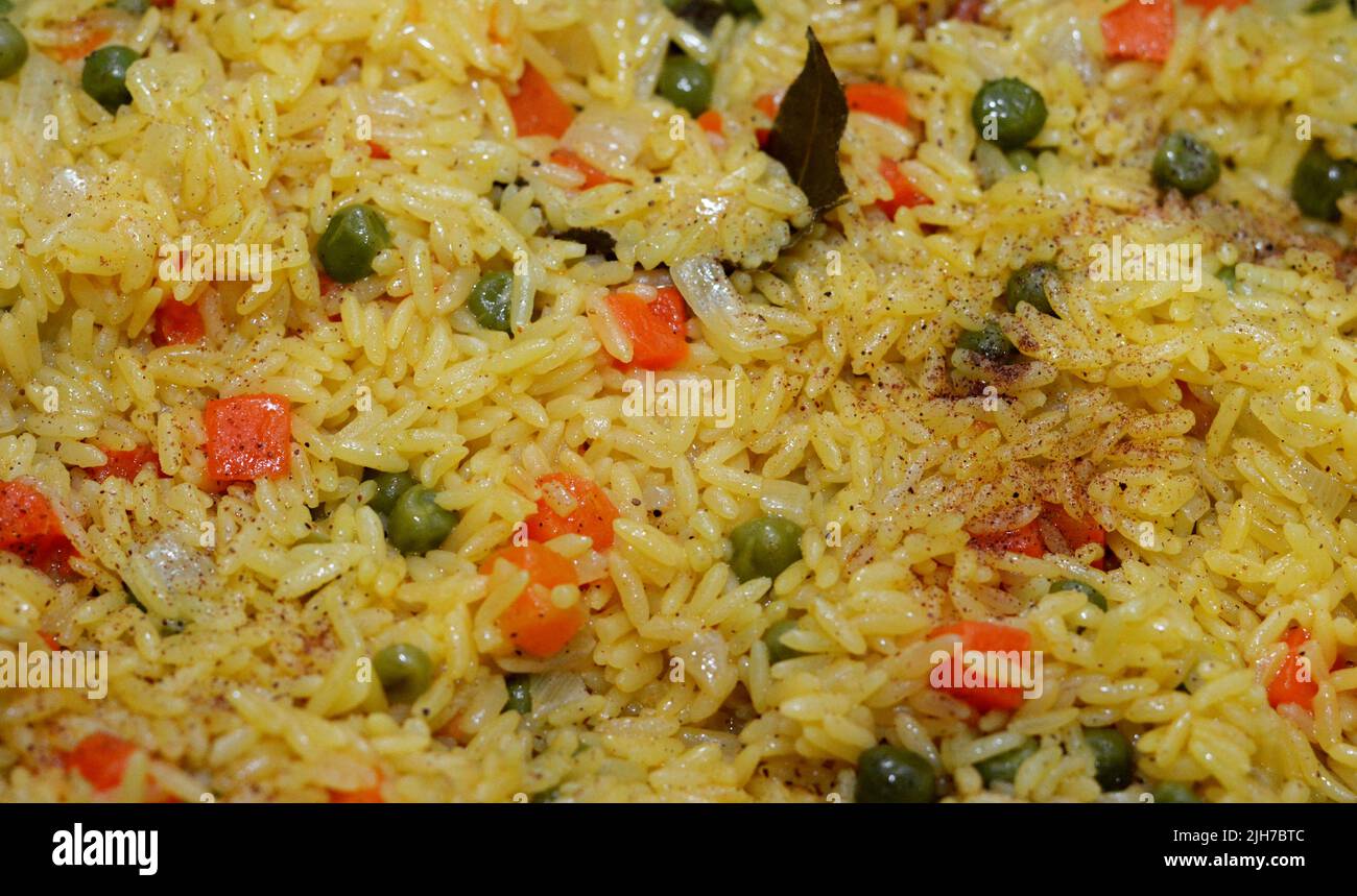 Hot steamed long grain yellow Basmati rice with vegetables peas and ...