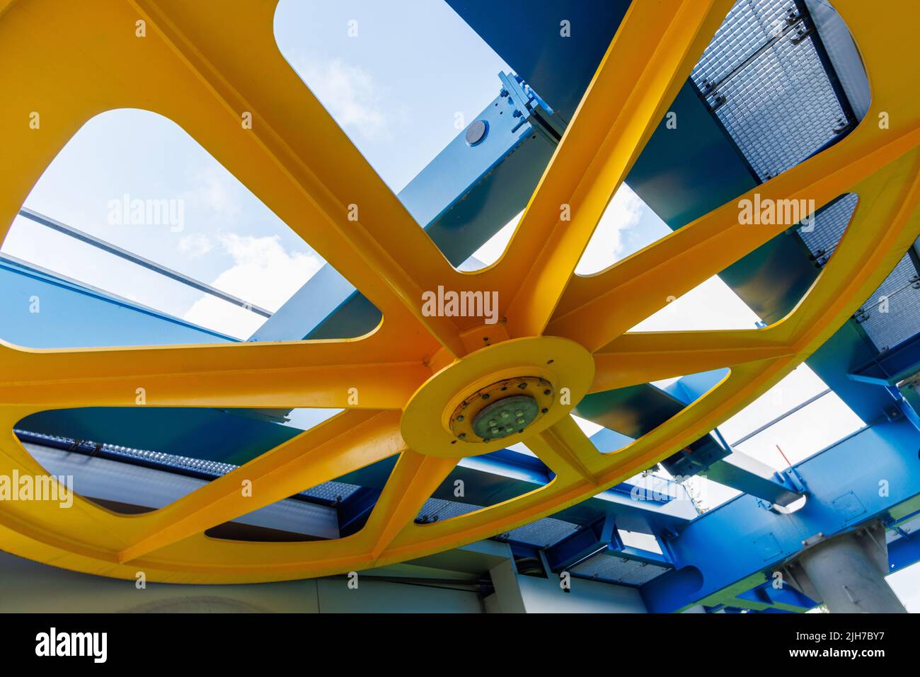 A yellow powerful metal wheel in a strong reliable mechanism on a ...