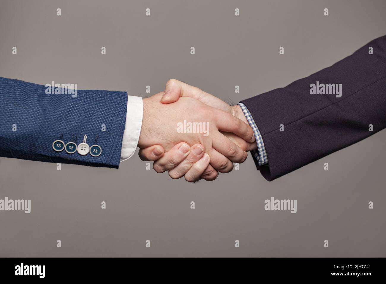 Businessmen making handshake on grey background. Business cooperation ...