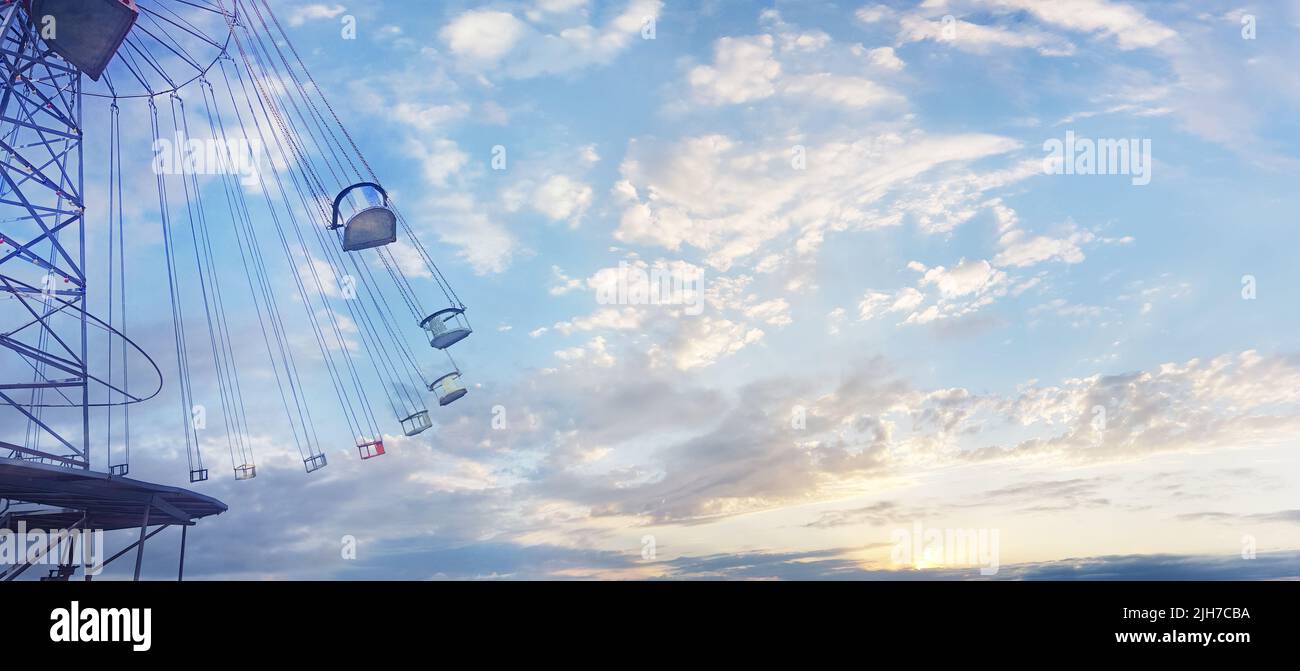 Swing chain carousel in amusement park against sky clouds background ...