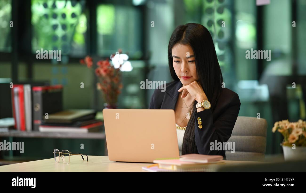 Focused millennial woman entrepreneur reading business information on ...