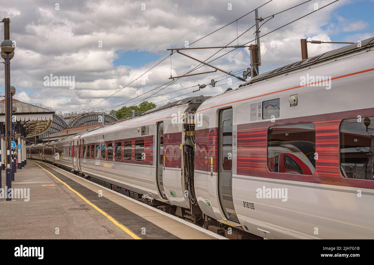 The carriages of a train speed past a railway station platform. There ...