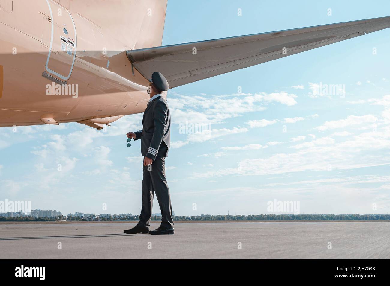 Pilot in uniform checks the aircraft before the flight in airport Stock ...