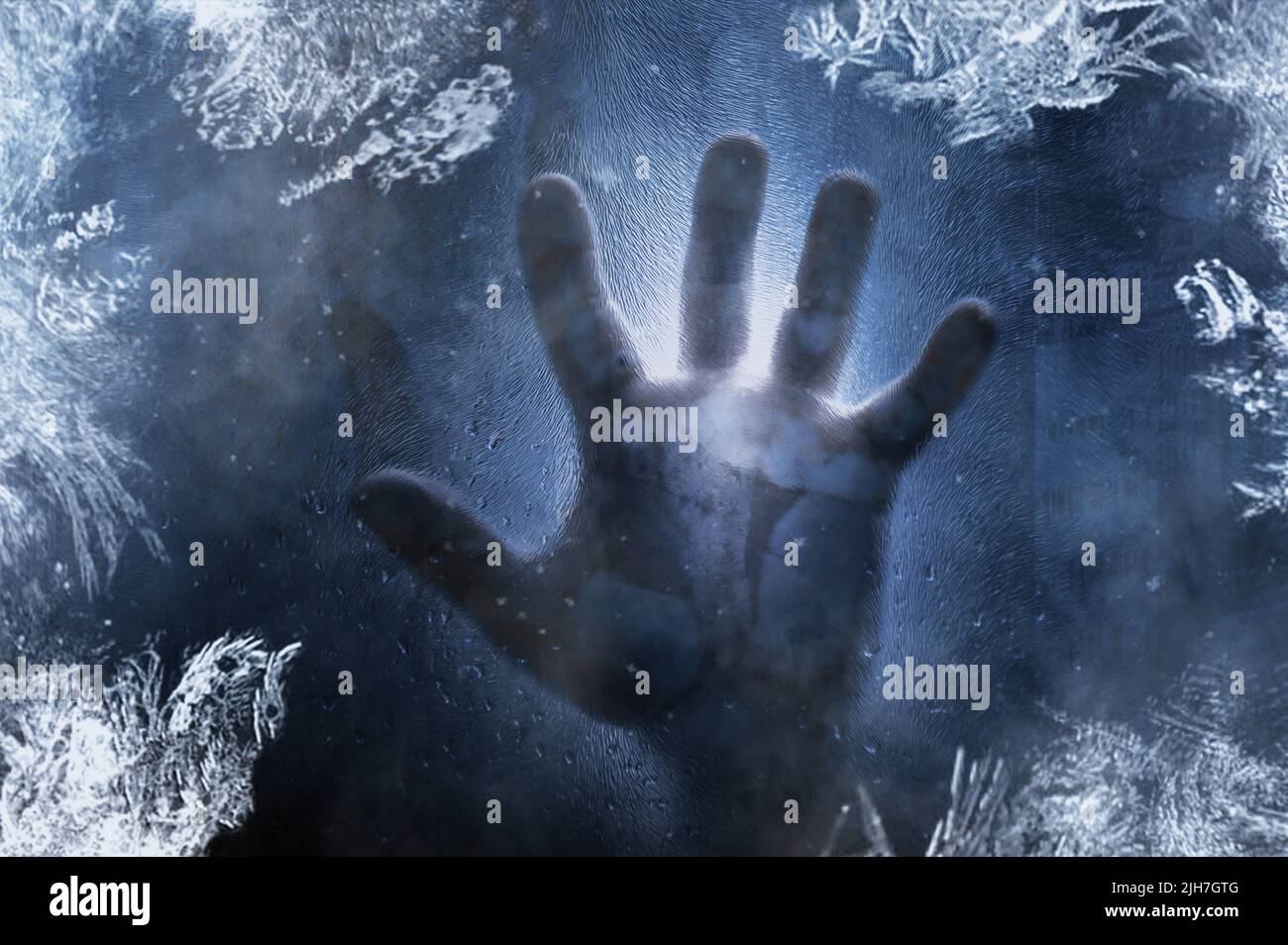Human hand against frozen glass and blue background. Toned image ...