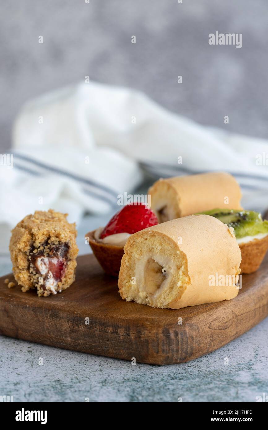 Delicious snacks. Roll cake, chocolate chip cake and fruit tart on a ...
