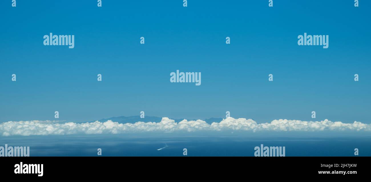 Long narrow band of cloud as a line between sky and ocean. Panoramic ...