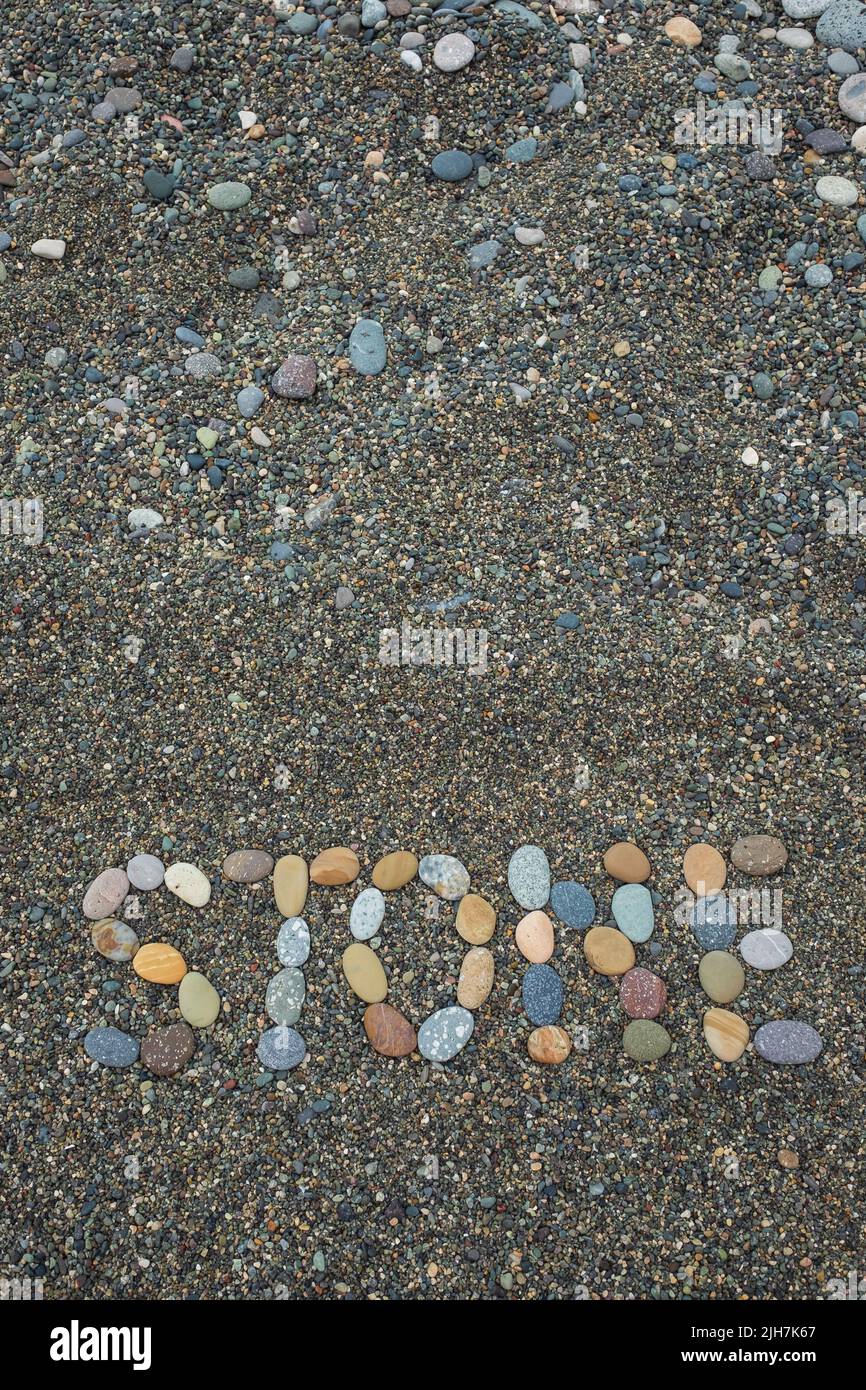 Text stone made from stones on sandy beach Stock Photo - Alamy