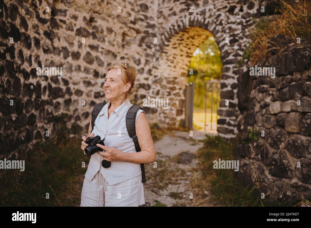 Elderly senior traveling backpacker mature woman tourist walking with ...