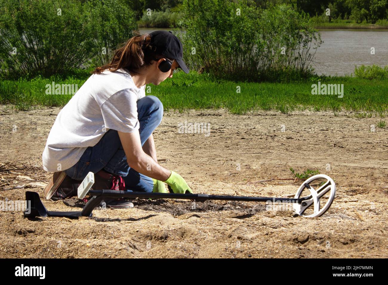 A guy walks along the beach looking for treasure with a wireless metal ...