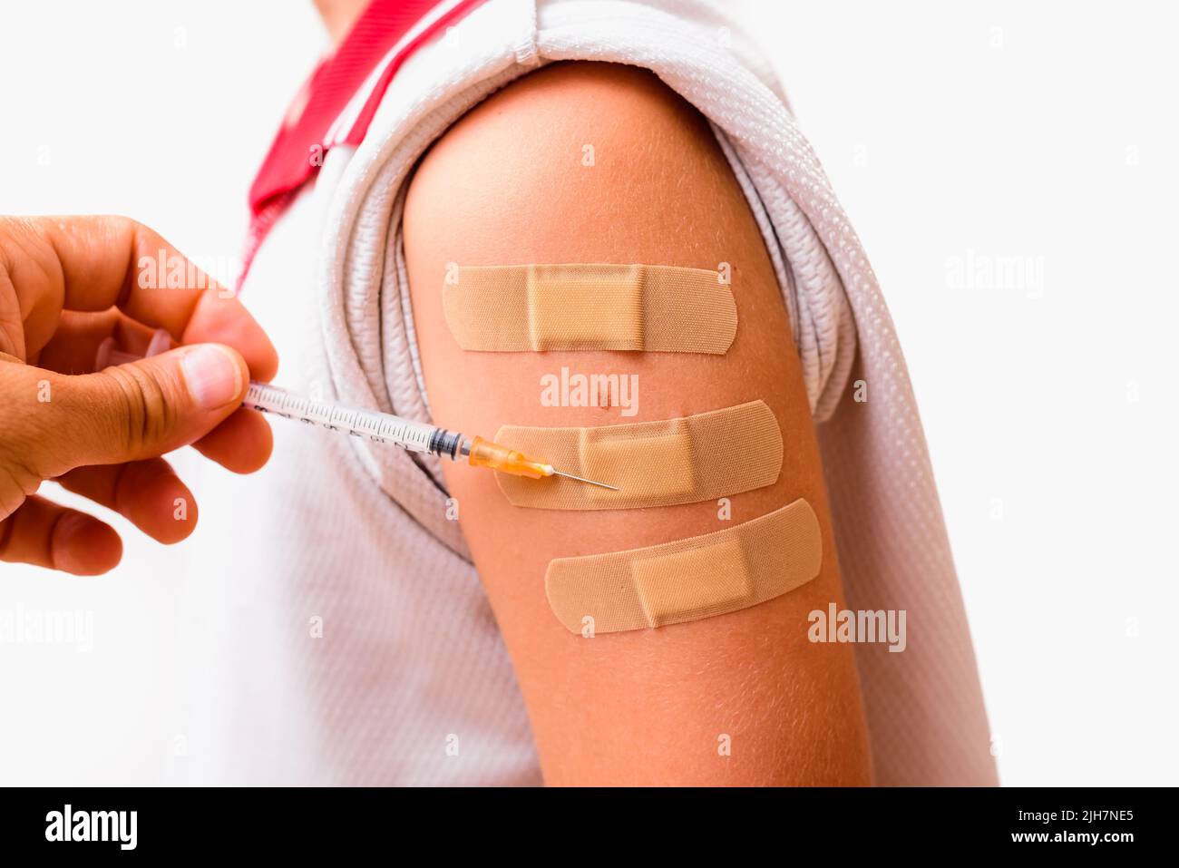 Poor recently vaccinated child with three band aids to feel good Stock ...