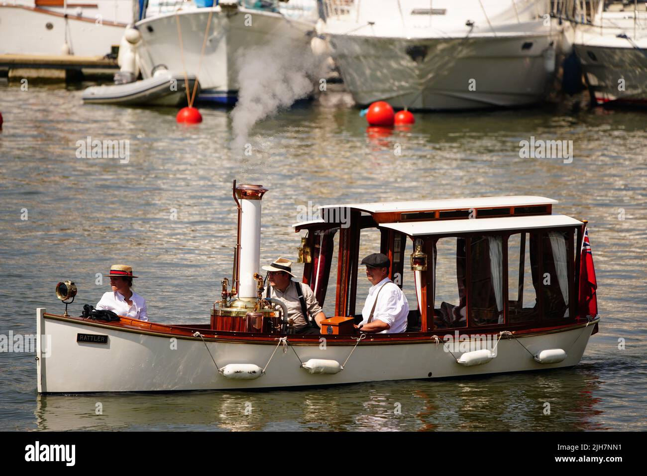 Three men in a steam-powered boat enjoying the good weather during the ...