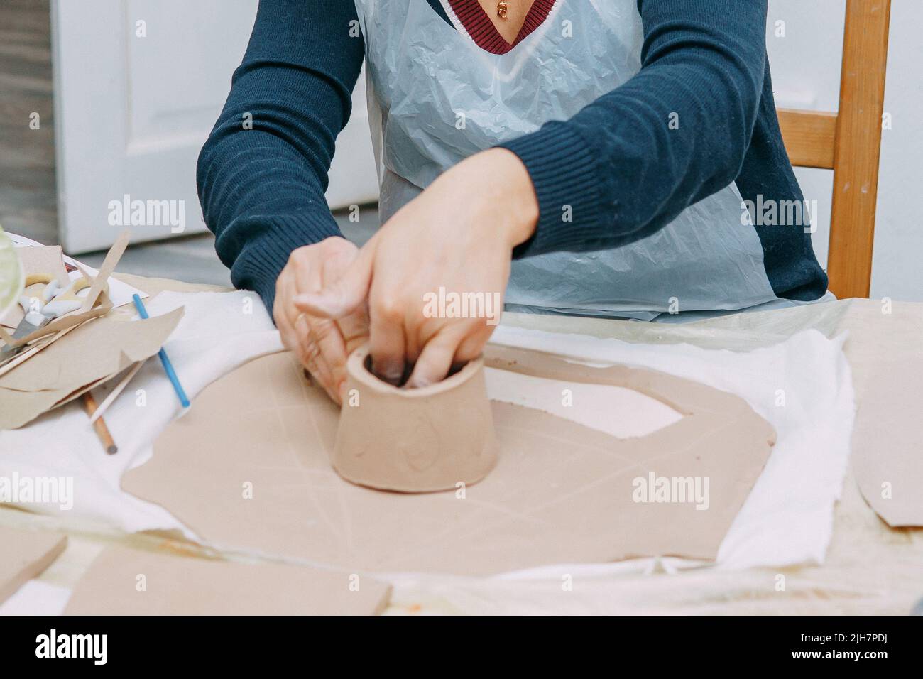 Women's hands knead clay, drawing elements of the product. Production ...