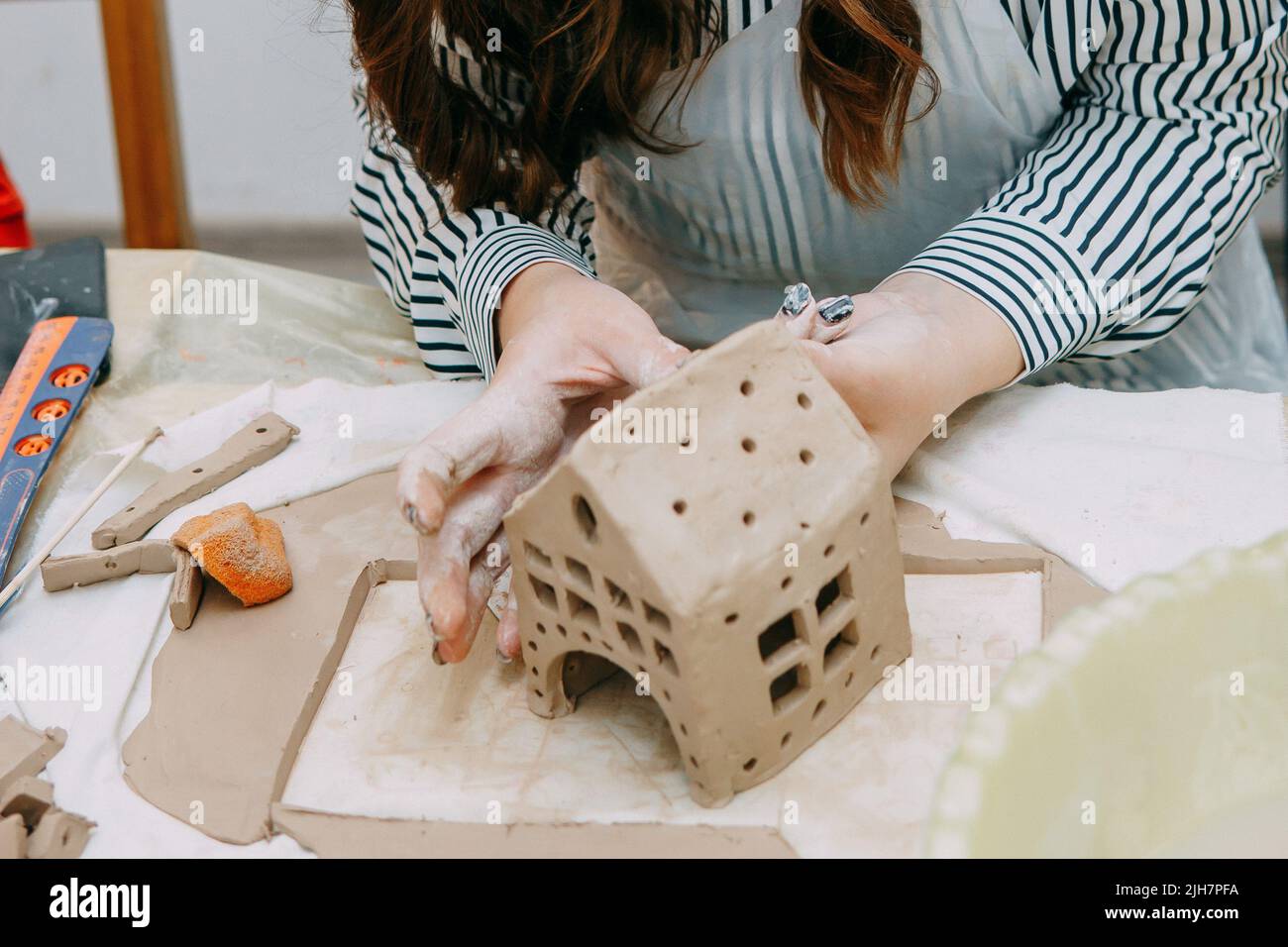 Women's hands knead clay, drawing elements of the product. Production ...