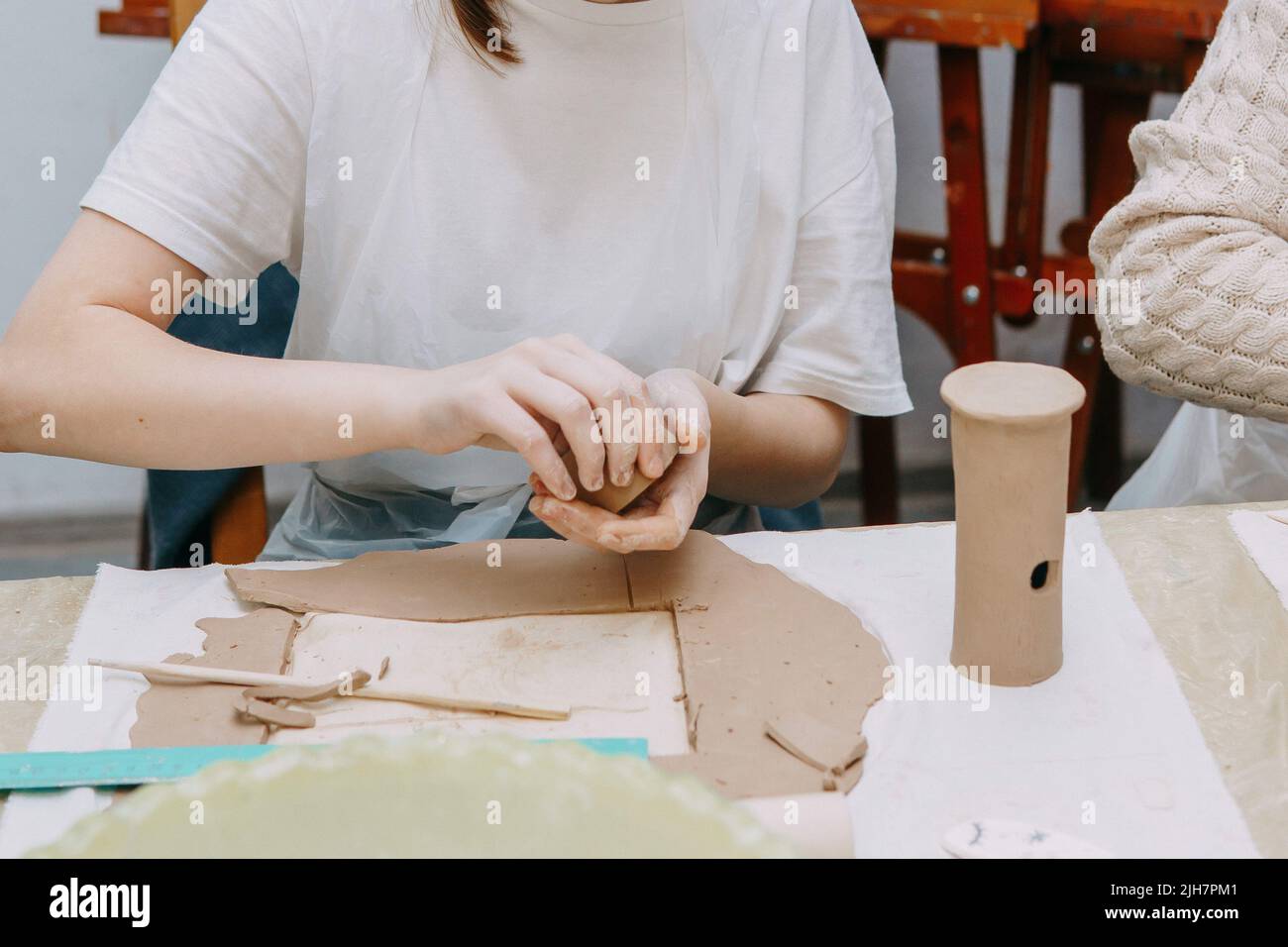Women's hands knead clay, drawing elements of the product. Production ...