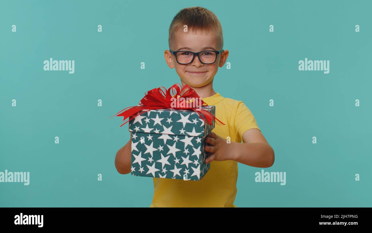 Positive smiling little toddler children boy presenting birthday gift ...