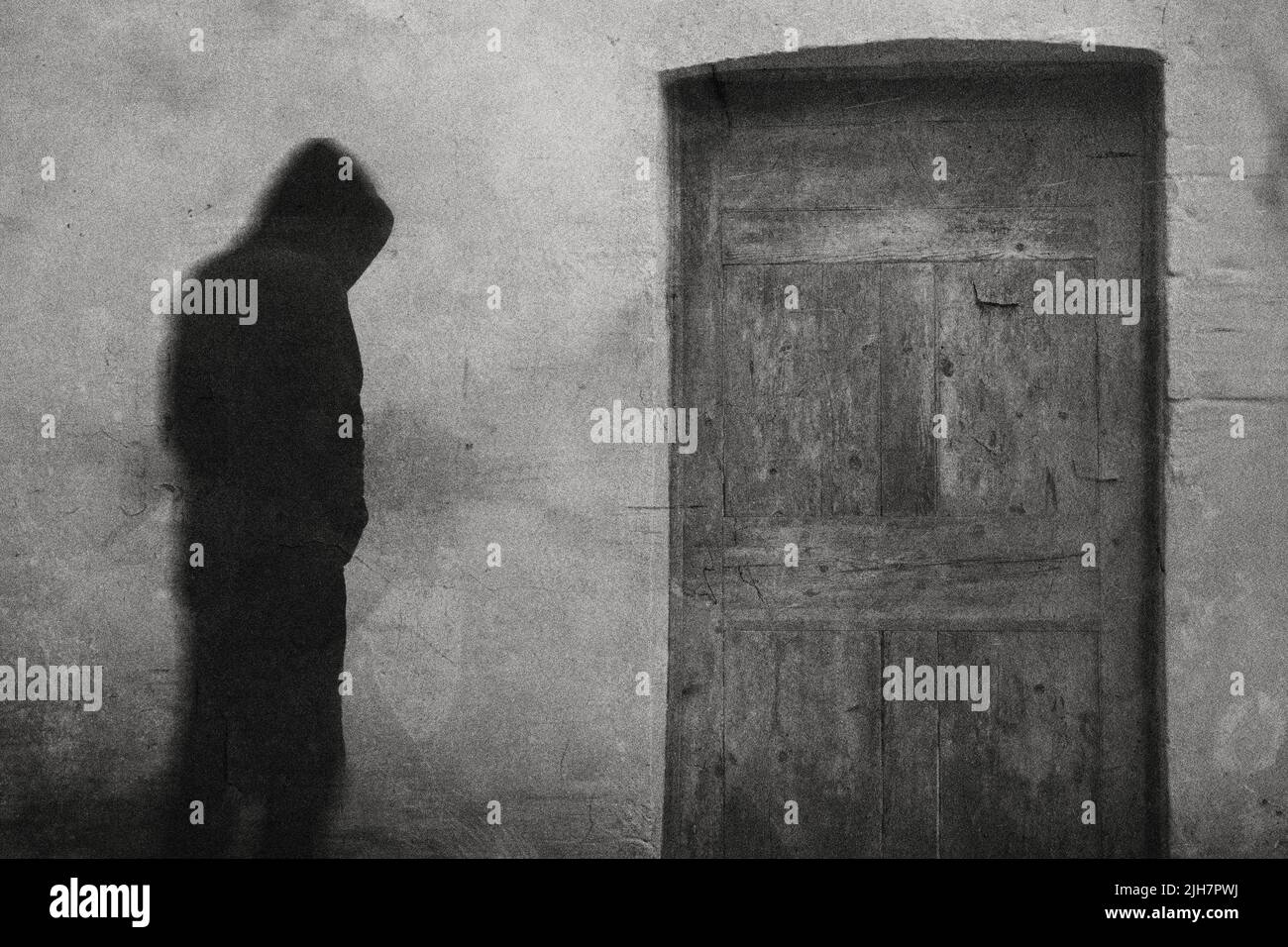 A ghostly spooky hooded monk. Standing by an old wooden door. With a ...