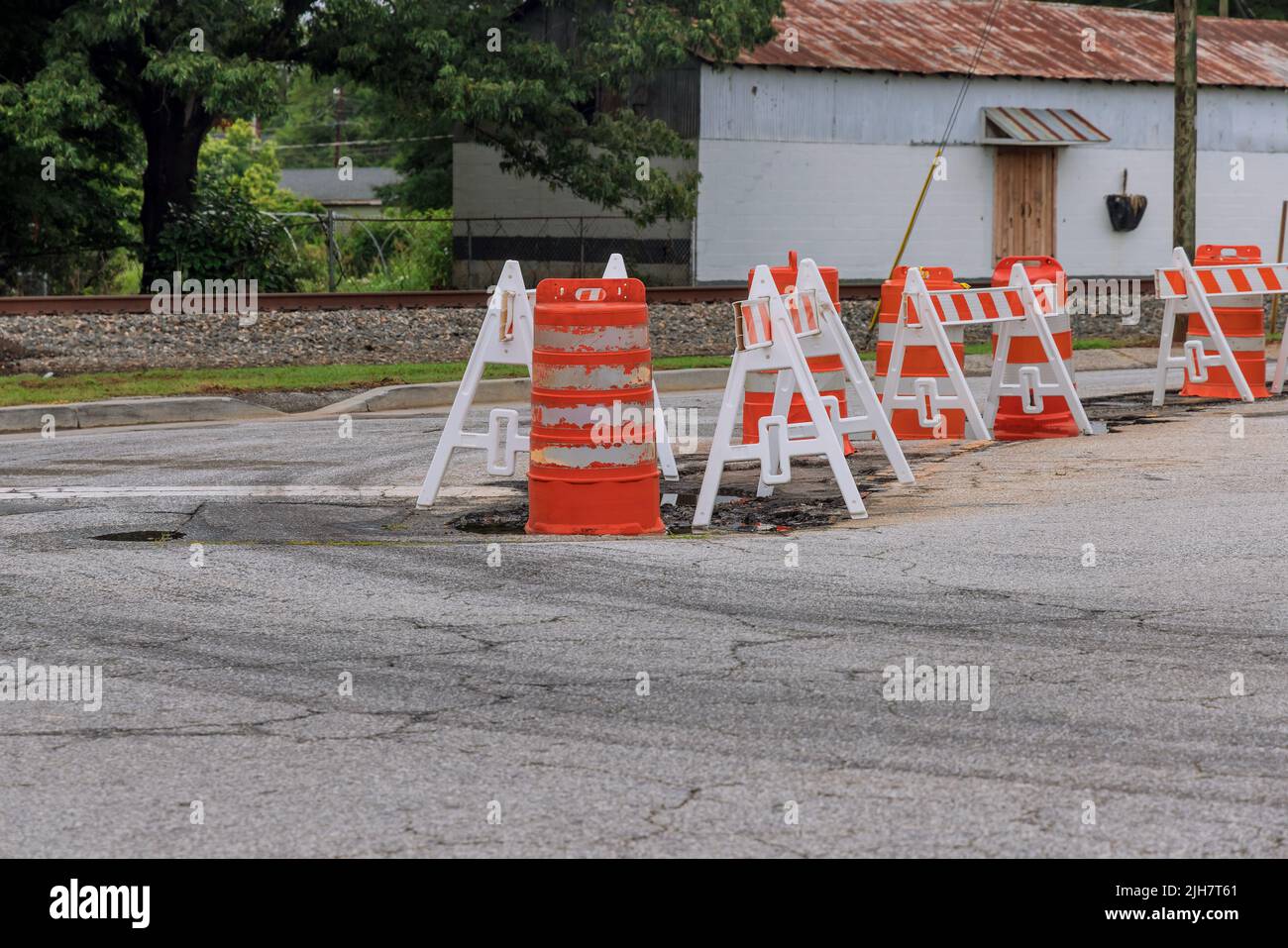 There are pits on the road repair site with signs indicating a ...