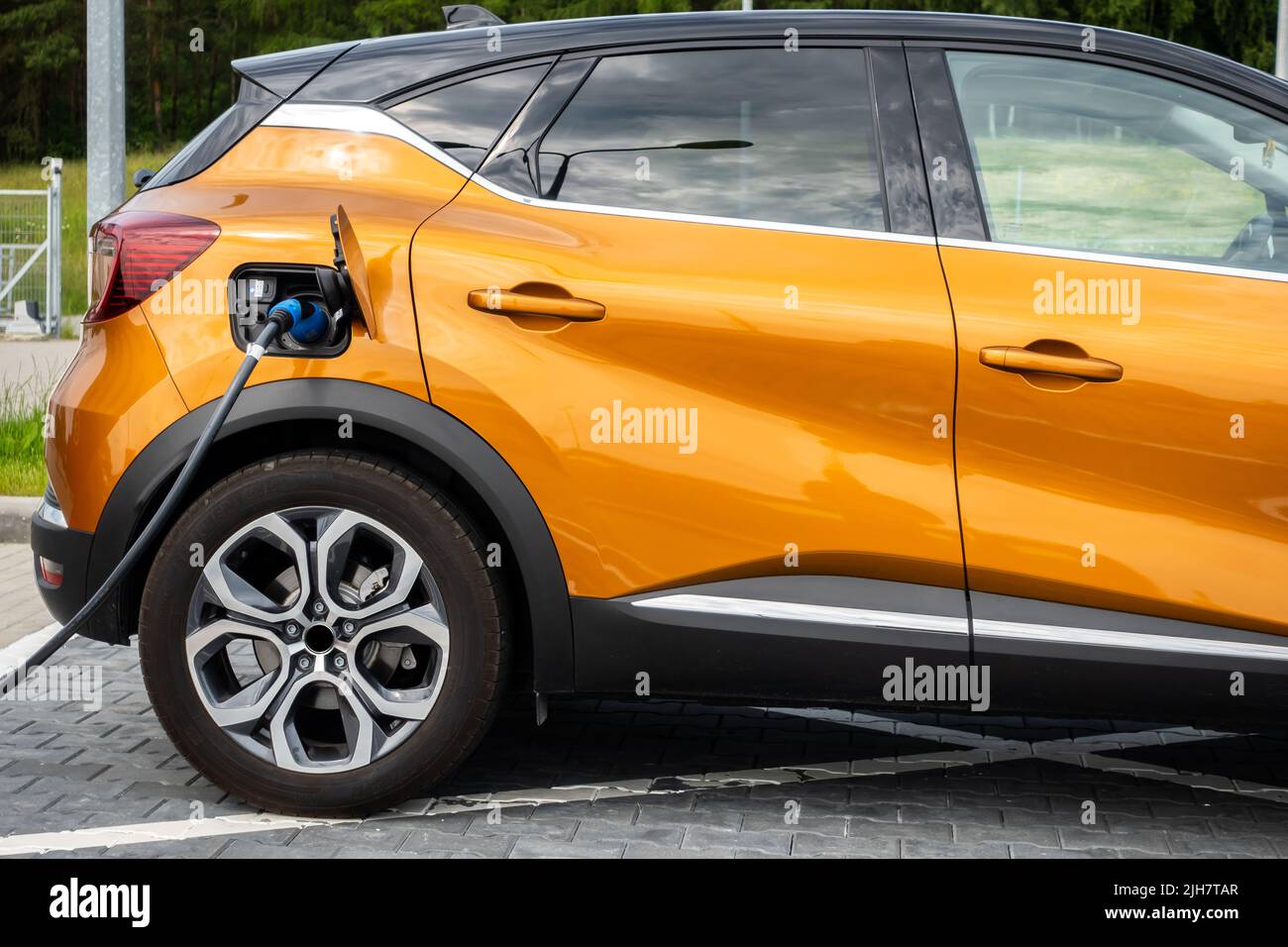 Orange electric car during charging. Modern electro mobility in ...