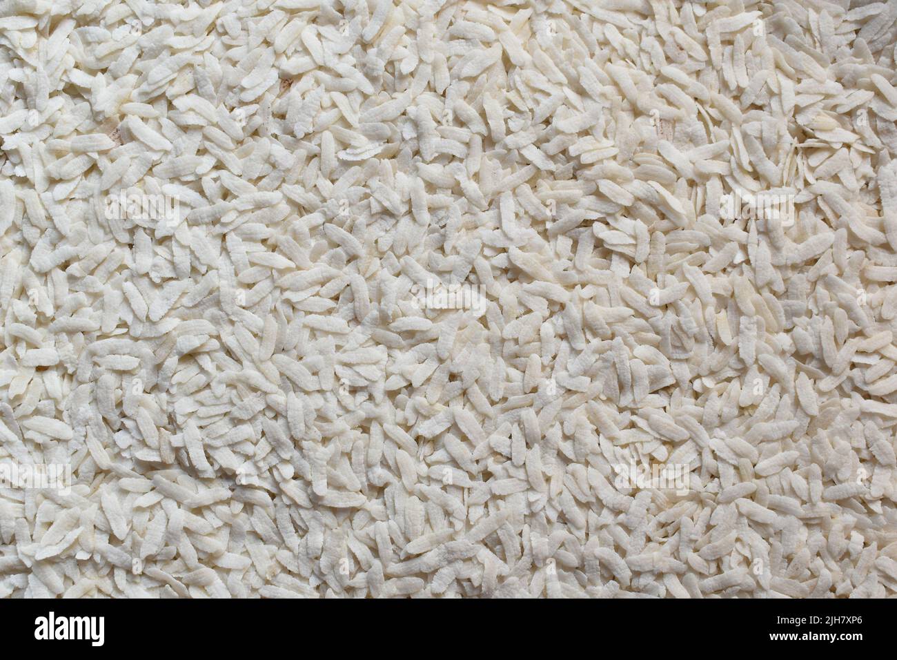 Raw whole dried flattened rice flakes Stock Photo - Alamy