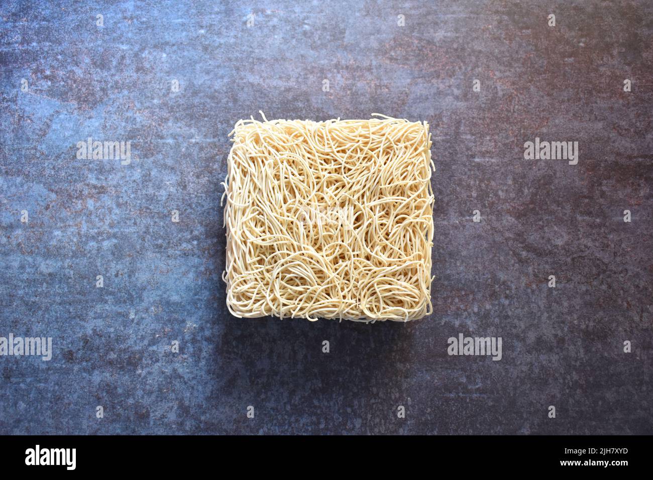 Raw whole dried square noodles block Stock Photo - Alamy