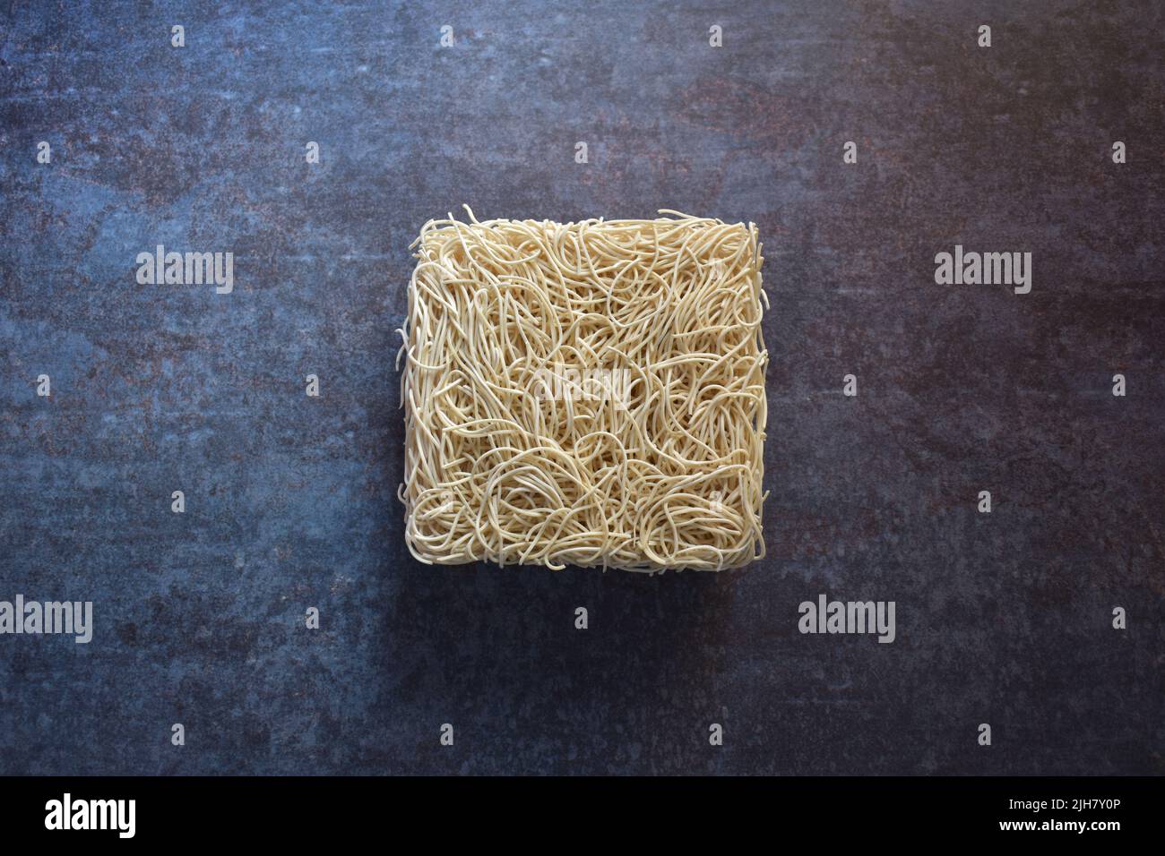 Raw whole dried square noodles block Stock Photo - Alamy