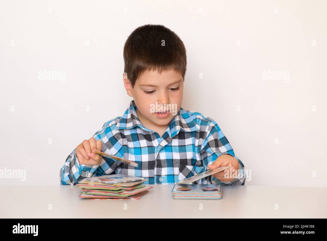 A boy of 4 years old plays with cards with pictures, educational ...