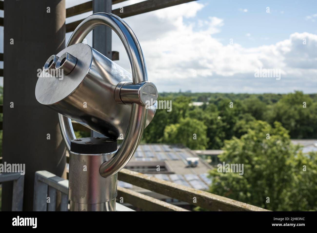 Tower viewer with city view, rooftops, green trees and blue sky with ...