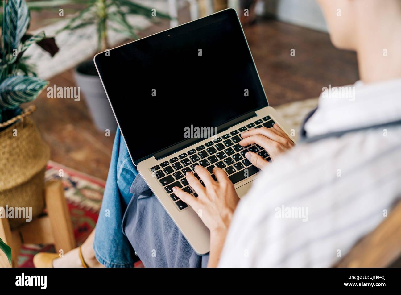Close-up of a laptop on the lap of an unrecognizable business woman ...