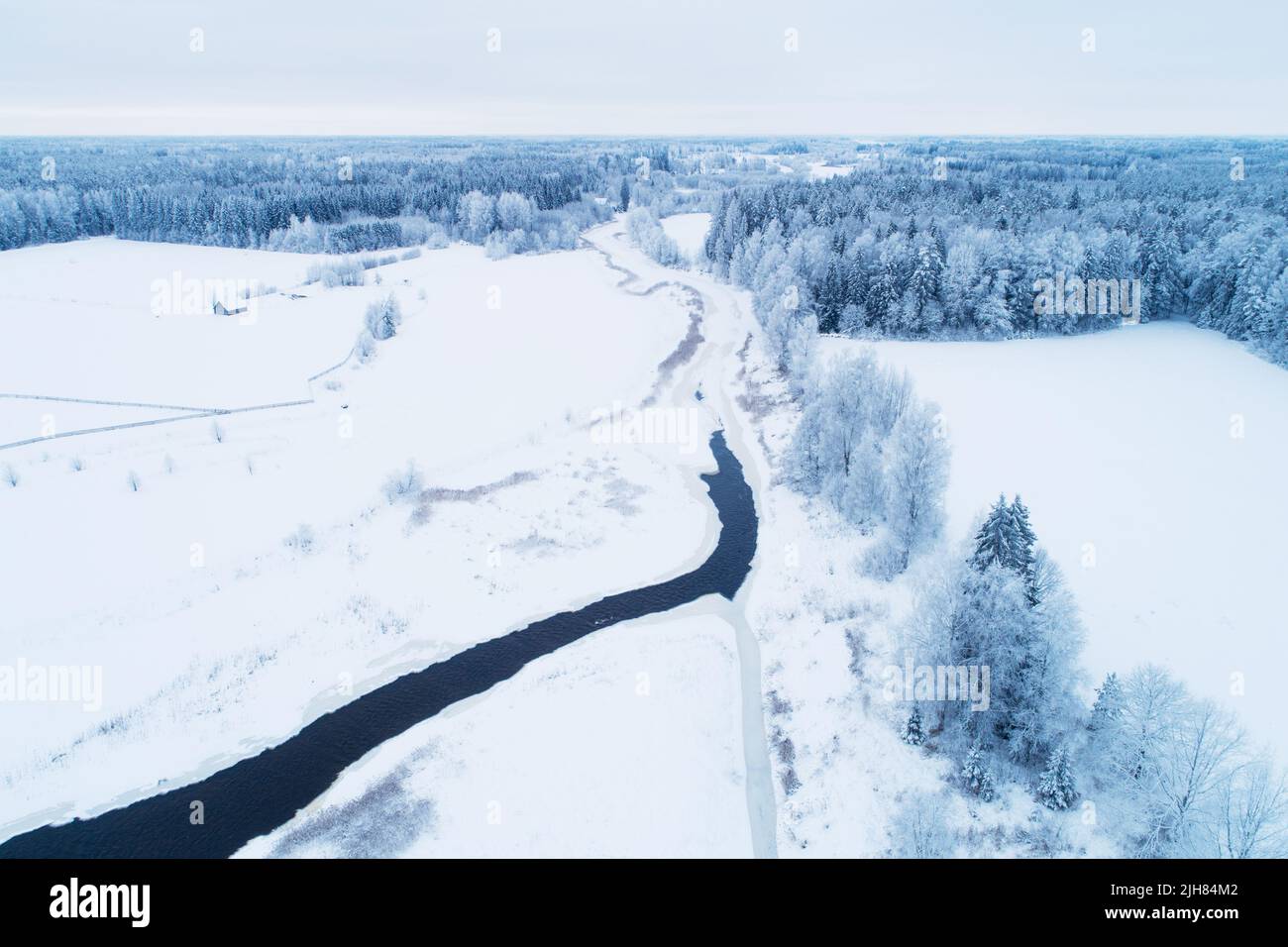 Aerial of a frosty and snowy rural landscape with a open river in ...