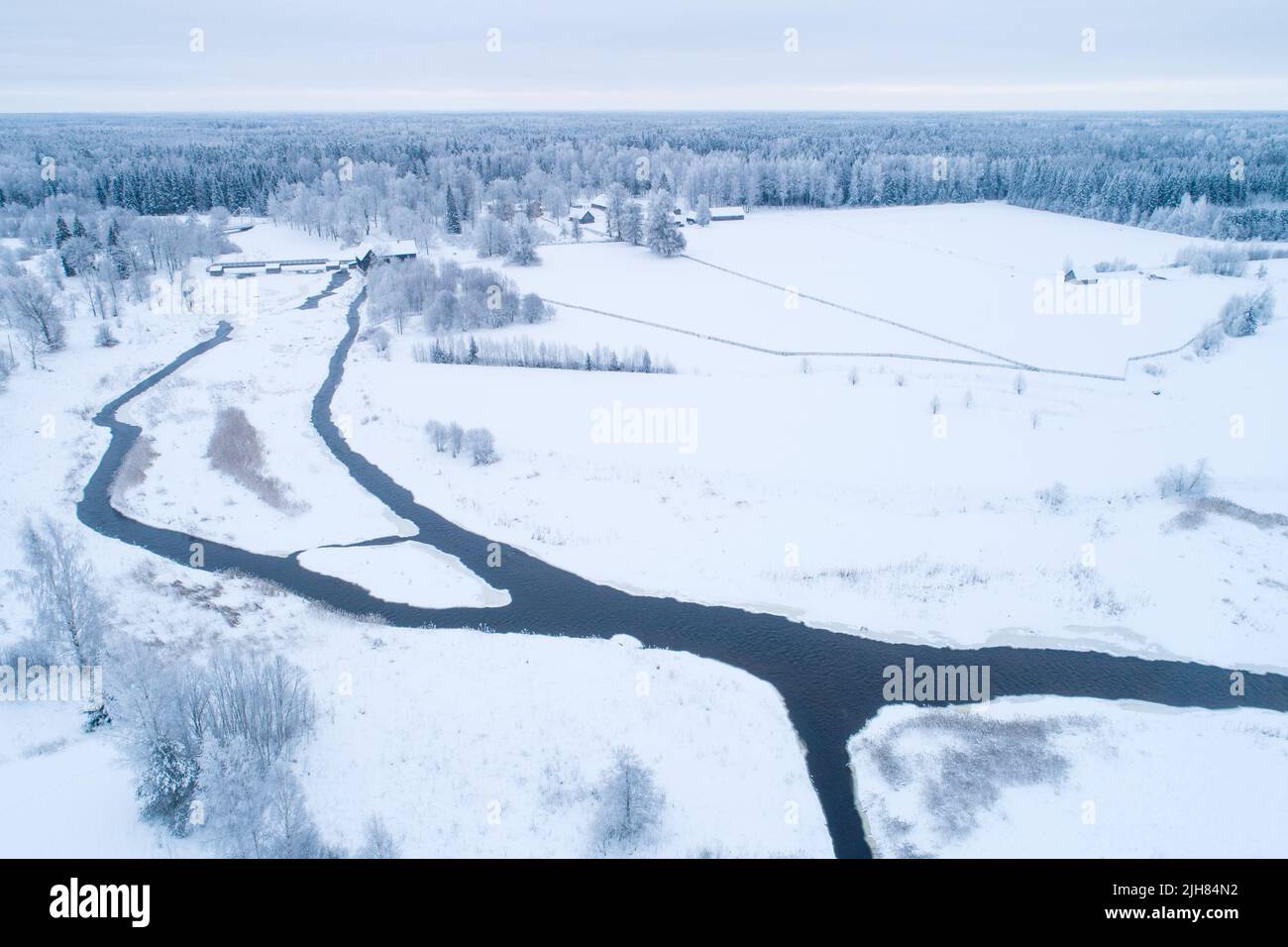 Aerial of a frosty and snowy rural landscape with a open river in ...