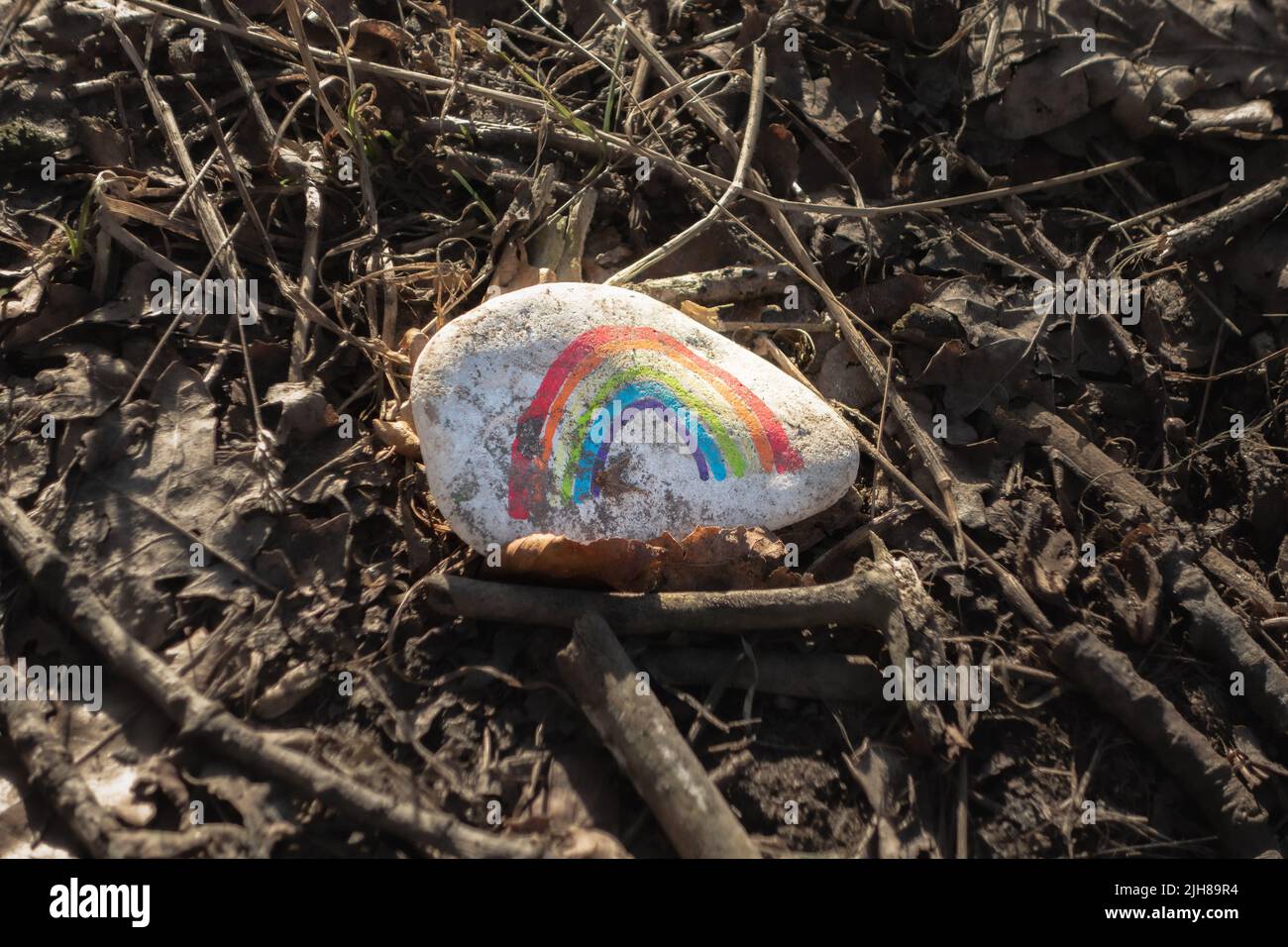 Rainbow paint o a small stone on the ground Stock Photo - Alamy