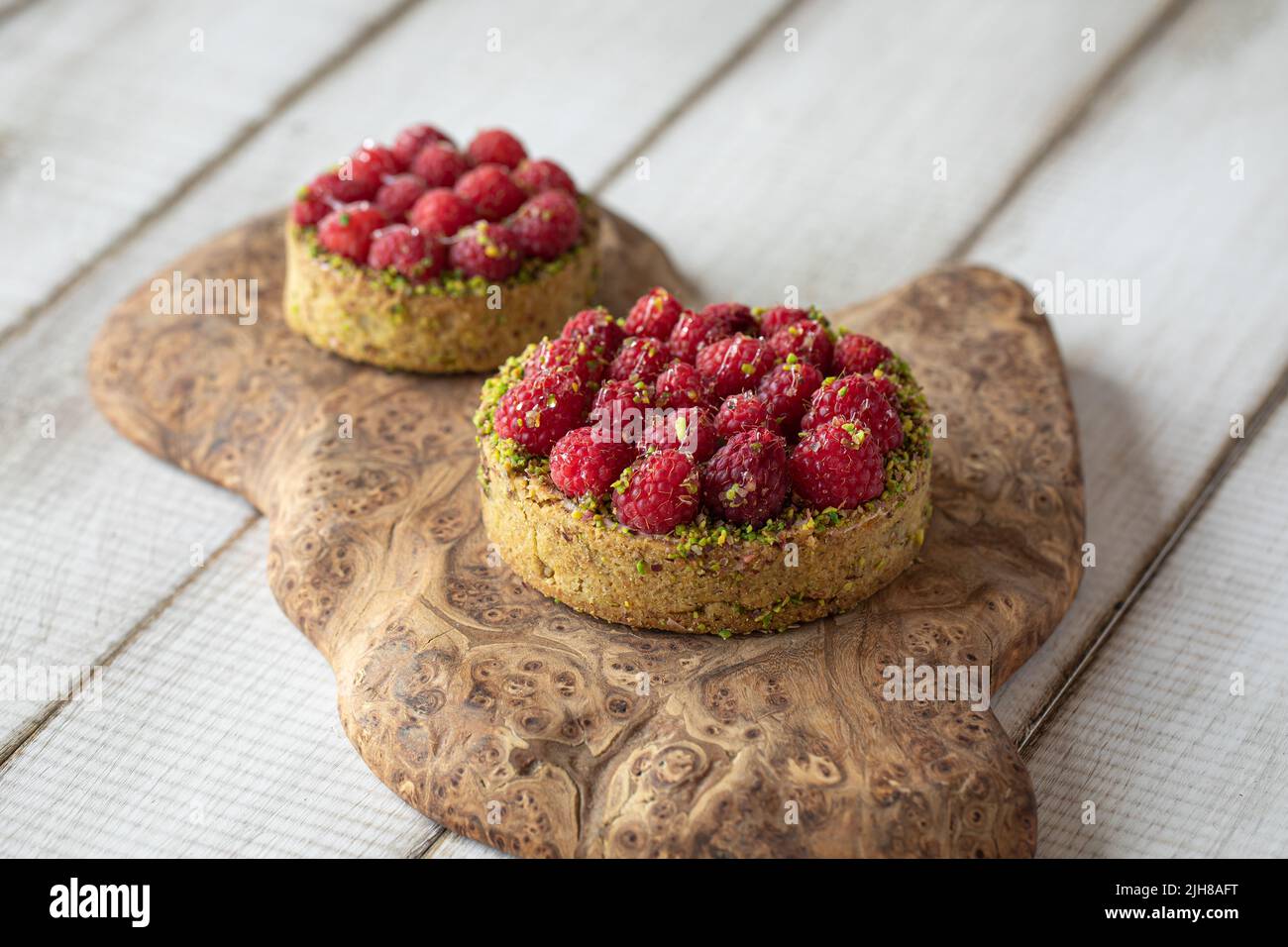 Two delicious raspberry tartlets with pistachios Stock Photo - Alamy
