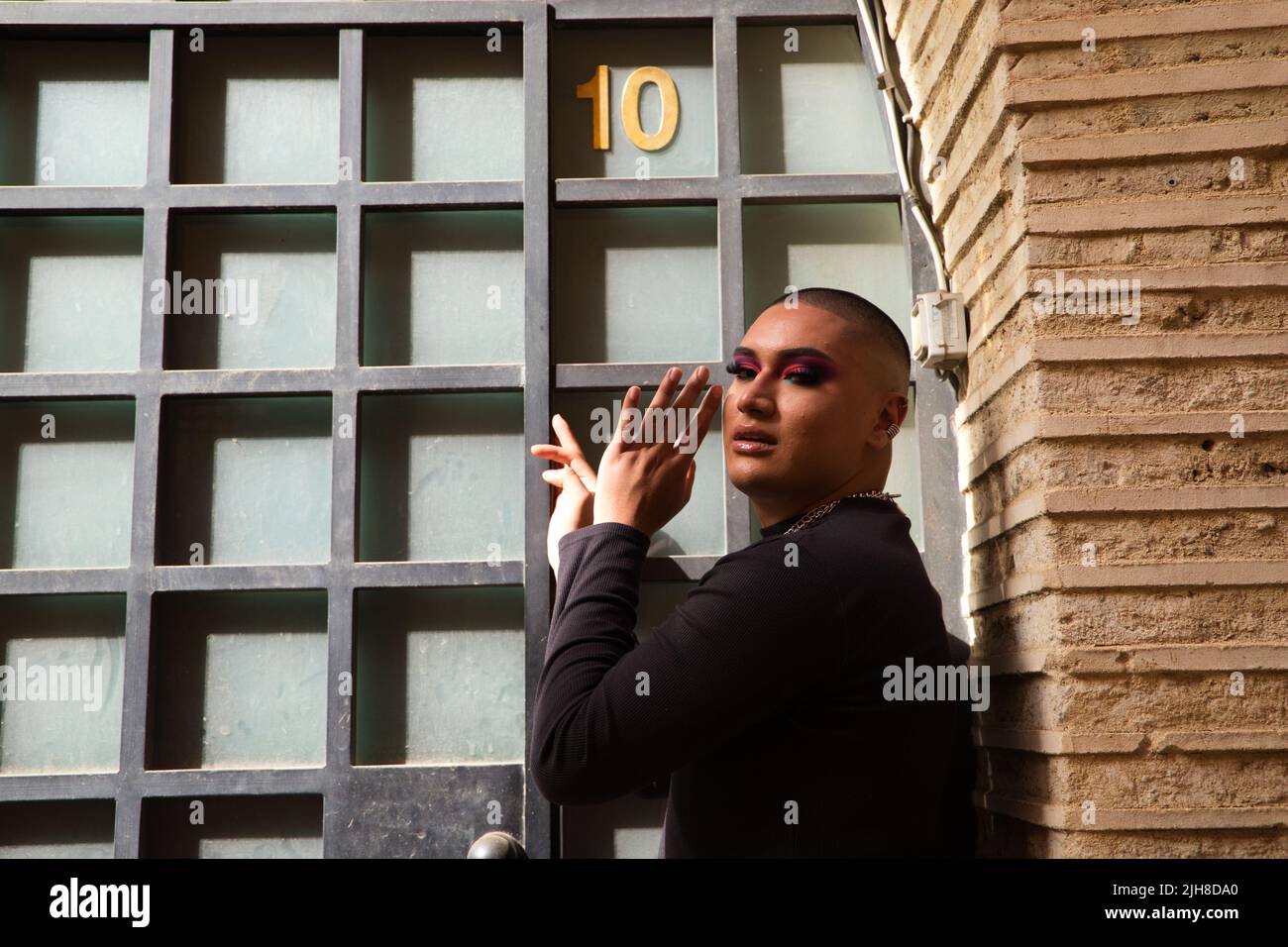 A Young Attractive Latin Non Binary Person Wearing Makeup Posing