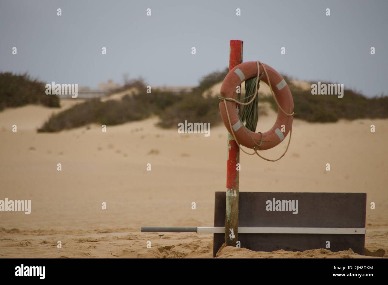 A red life ring and rope hanging from the pole near a sandbar Stock ...