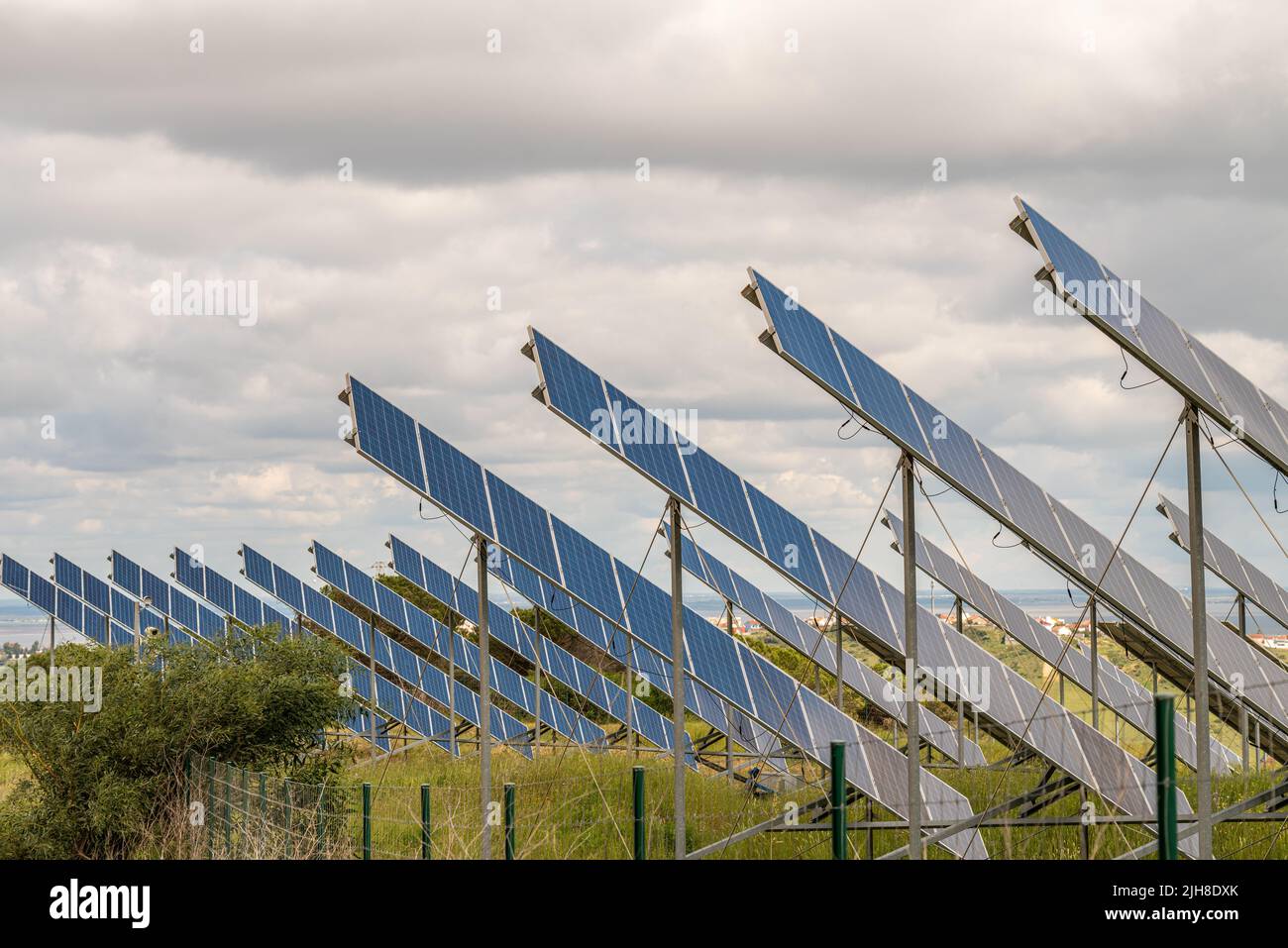 A view of solar panels in a field under the cloudy sky Stock Photo - Alamy