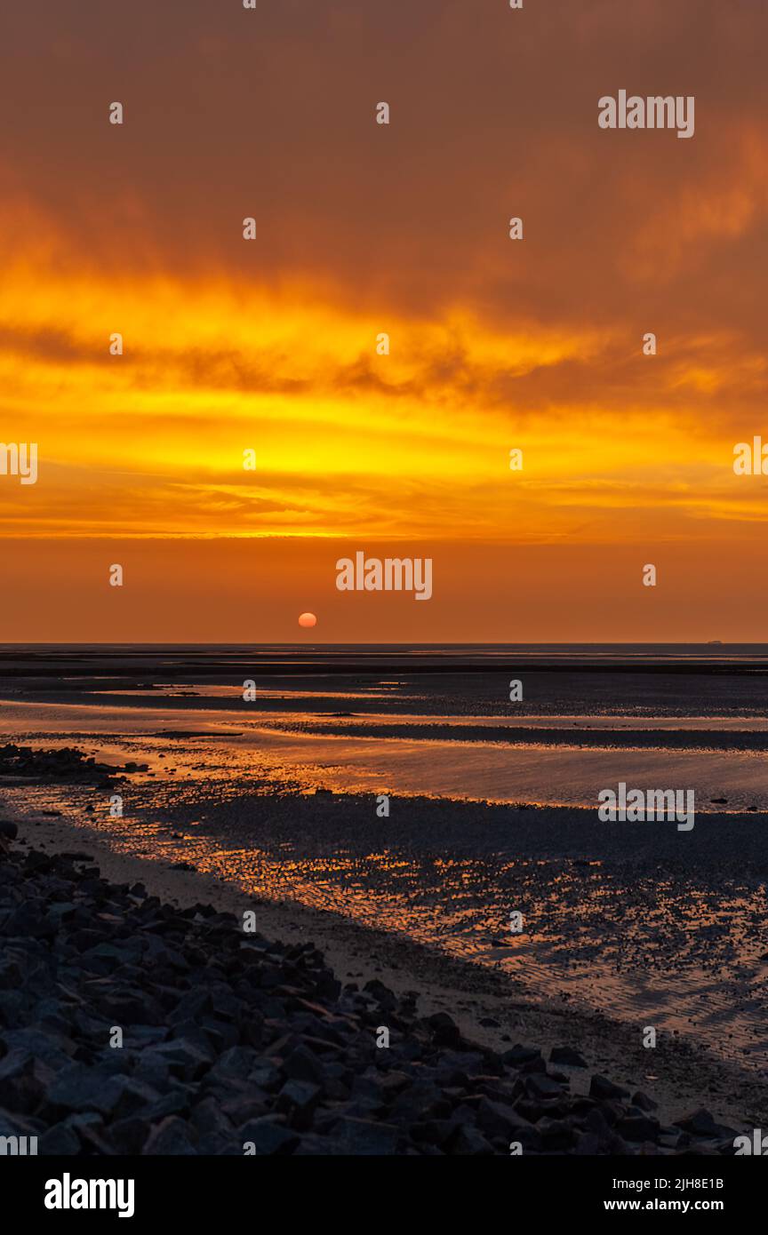 A scenic shot of the Northern sea in Germany during a golden sundown ...