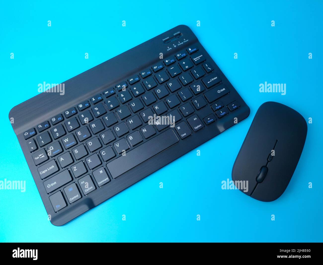 A Black Bluetooth Wireless Keyboard And Wireless Mouse On A Blue