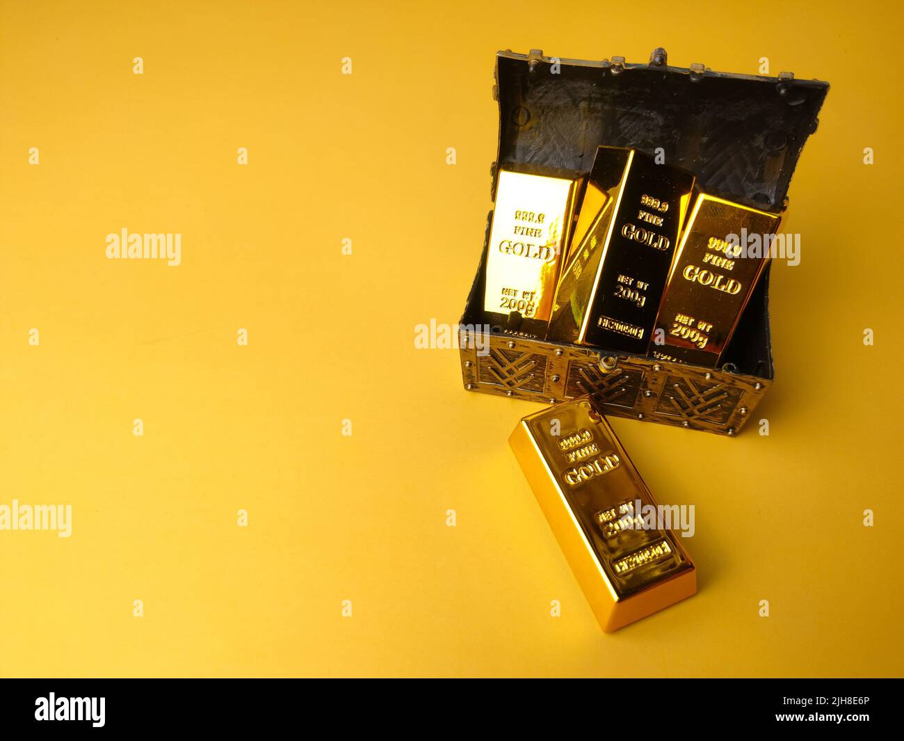 A treasure box with gold bar on a yellow background Stock Photo - Alamy