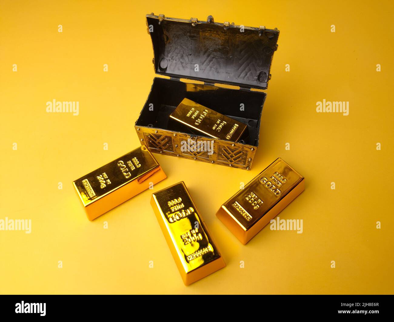 A treasure box with gold bar on a yellow background Stock Photo - Alamy