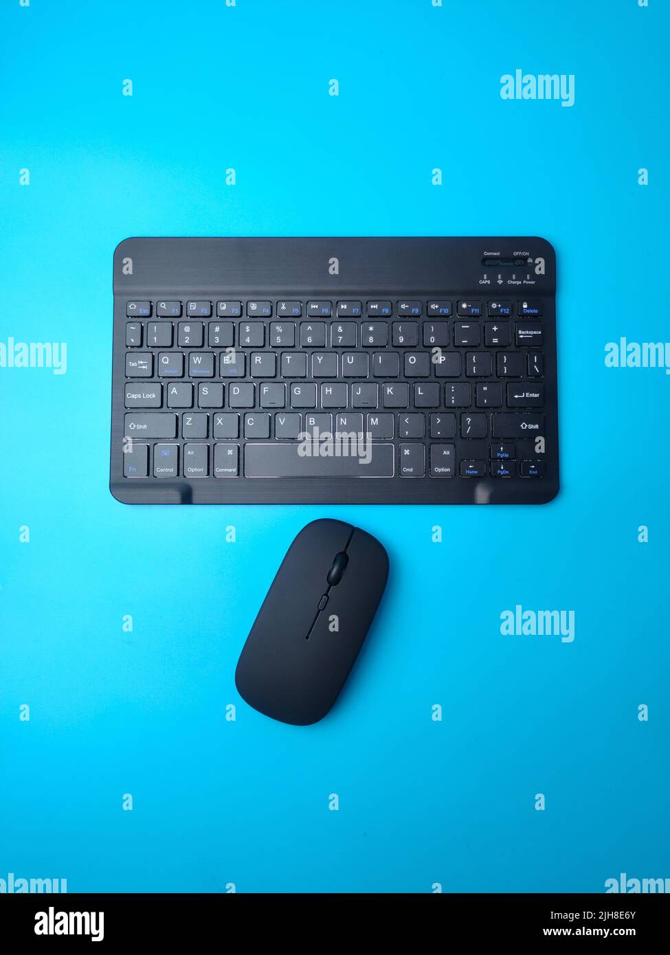 A Black Bluetooth Wireless Keyboard And Wireless Mouse On A Blue