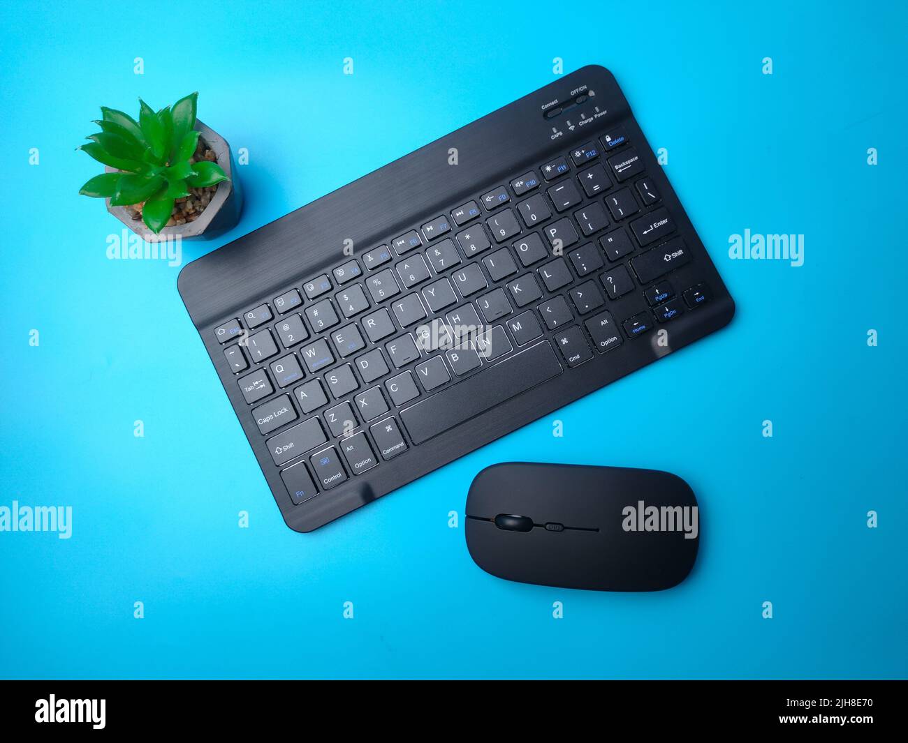 A Black Bluetooth Wireless Keyboard And Wireless Mouse On A Blue