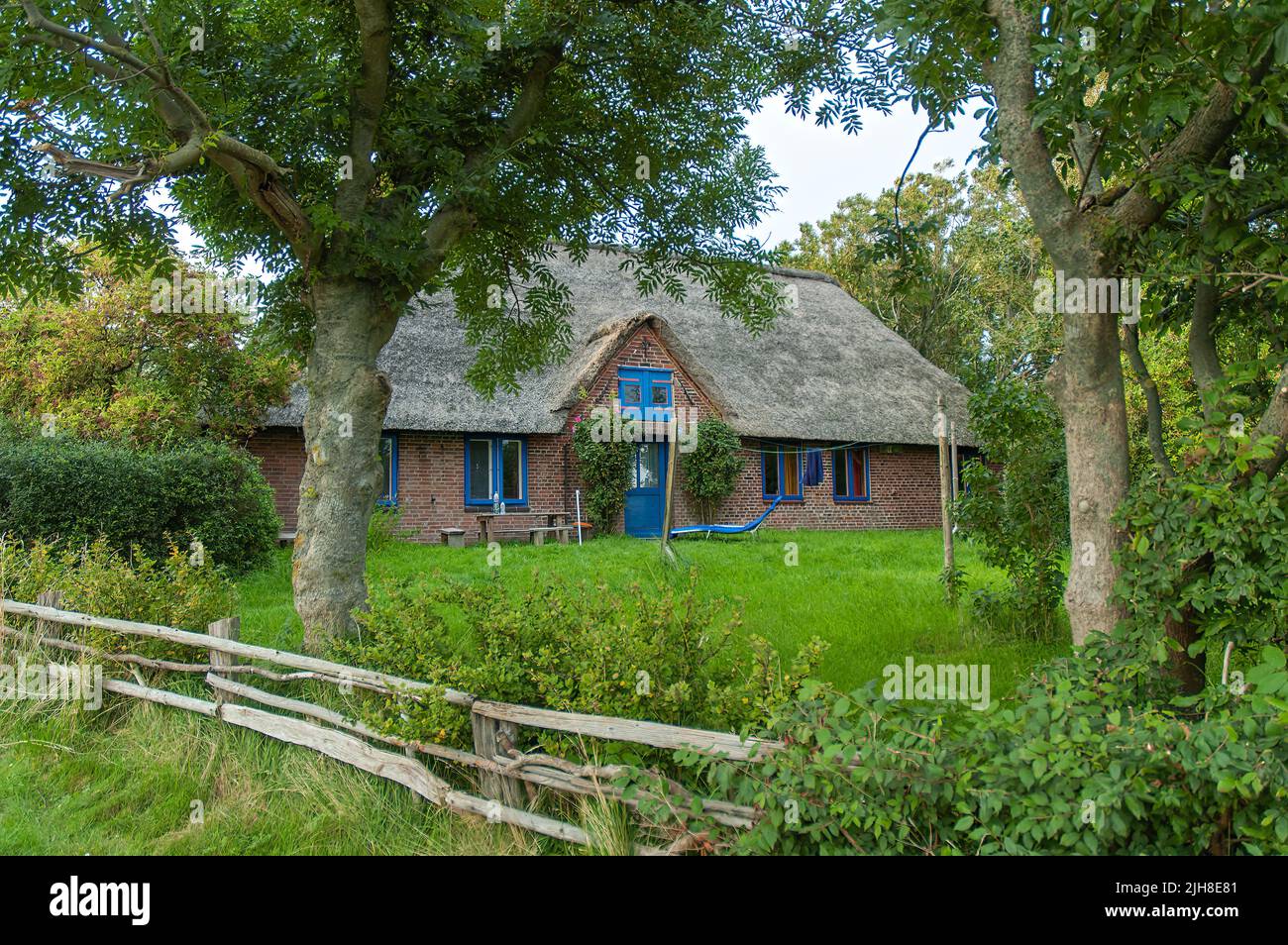 A run-down brick house with blue windows and doors in Westerhever ...
