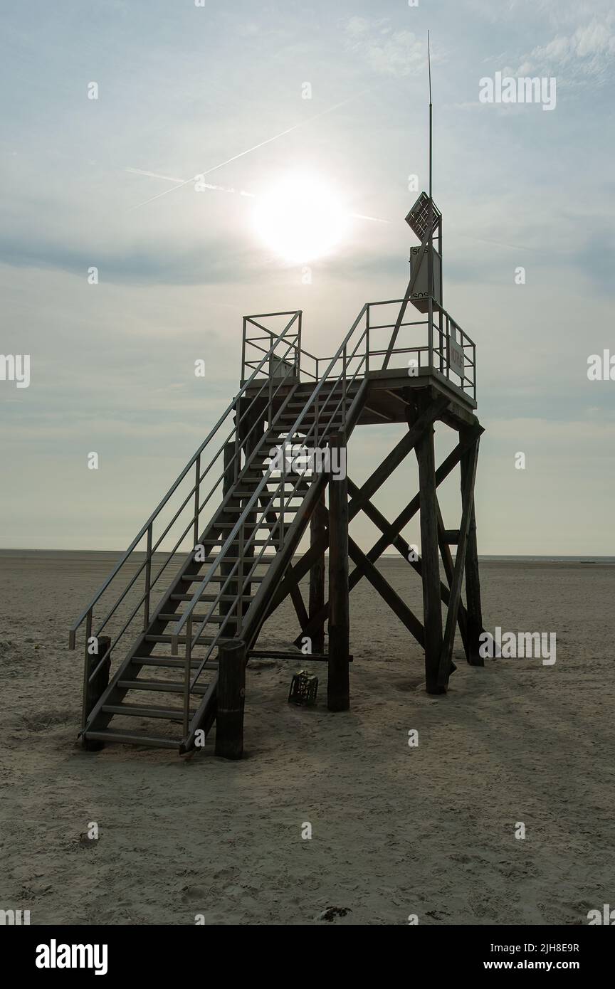 A vertical shot of a metal lifeguard station on an empty beach in the ...