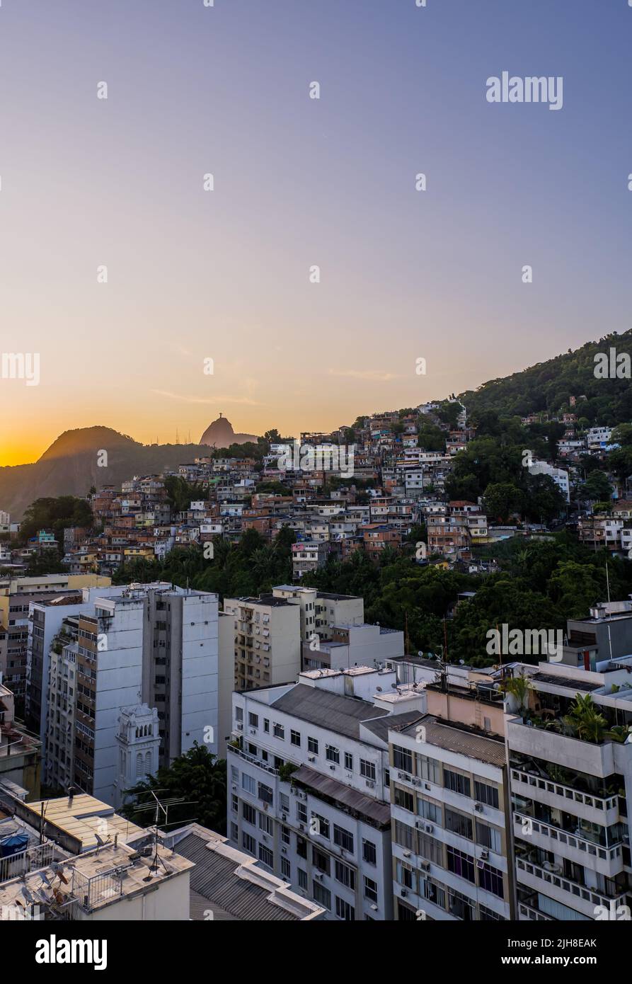 A vertical sunset view of Leme and a favela and Christ the Redeemer in ...