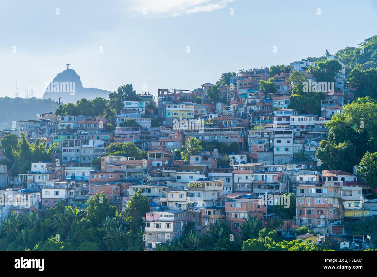 A sunset view of a favela and Christ the Redeemer in the background ...