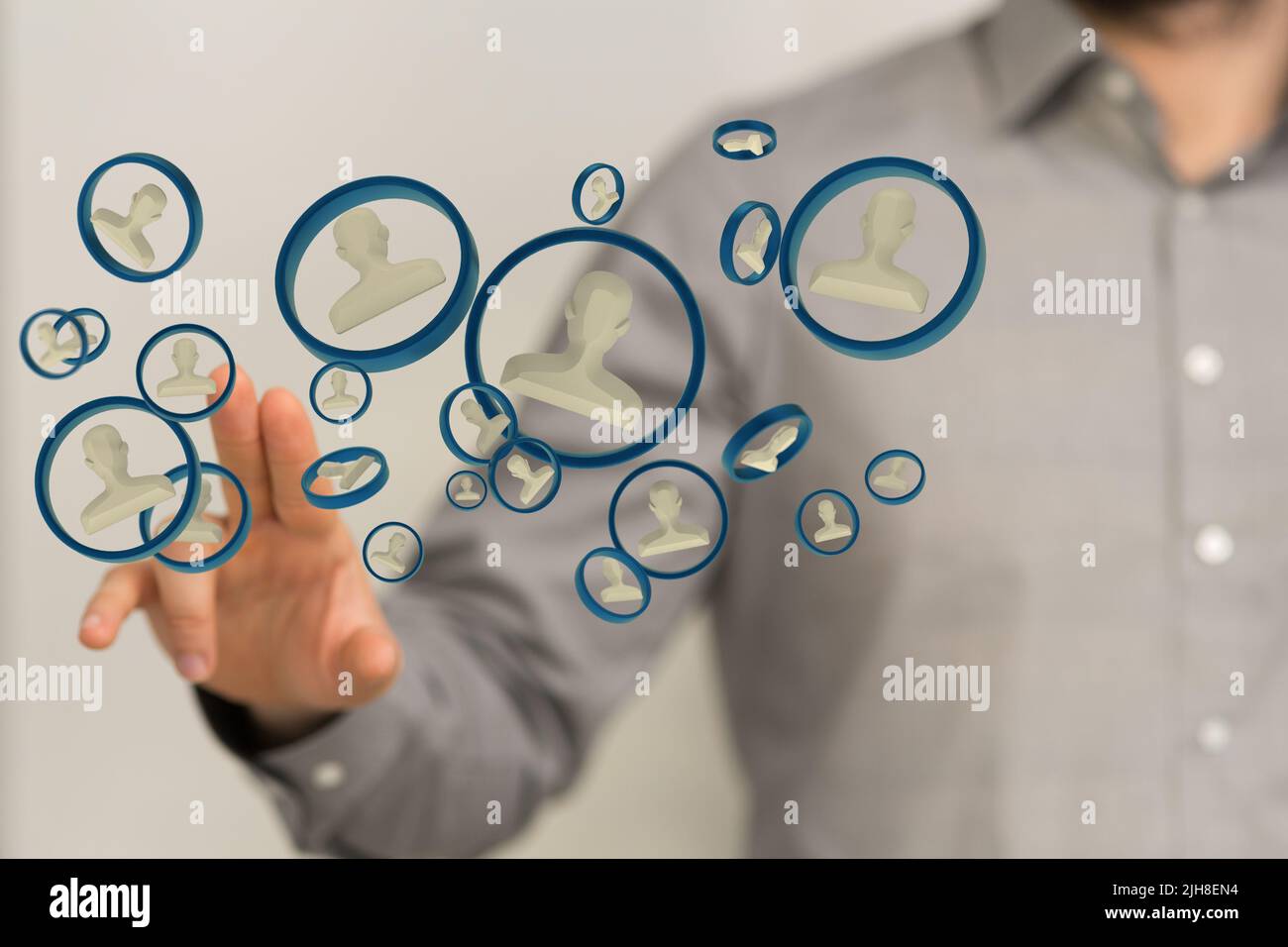 A man touching a floating render of people icons Stock Photo - Alamy